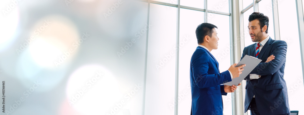 Two business people talk project strategy at office in widen view ...