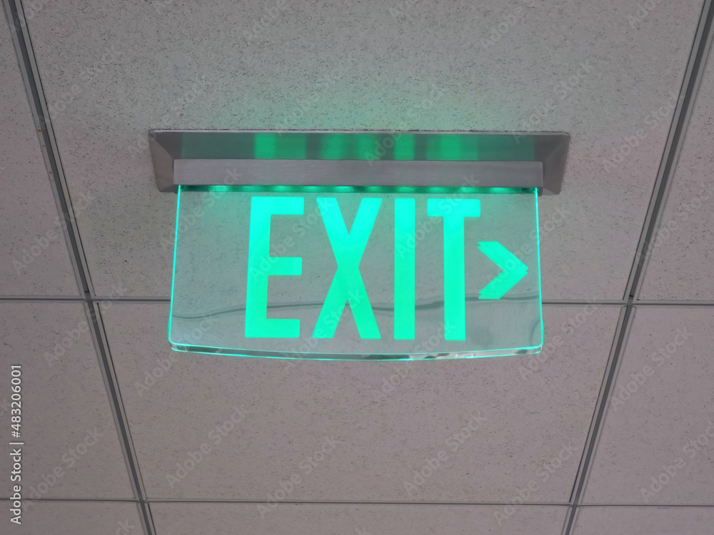Illuminated Overhead Green Exit Sign In Modern Office Building Stock ...