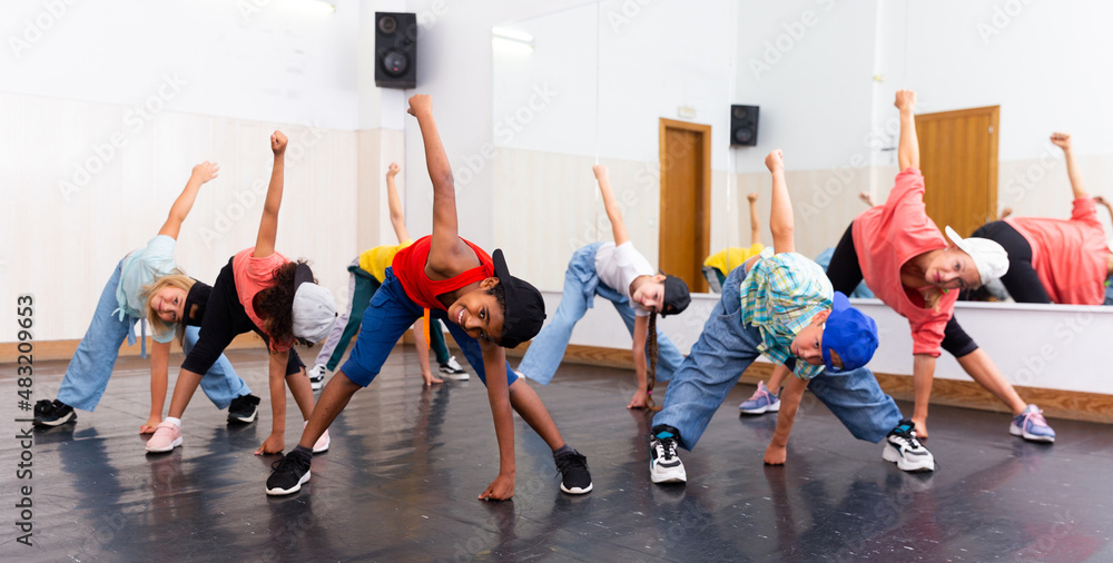 Cheerful preteen girls and boys hip hop dancers doing dance workout ...