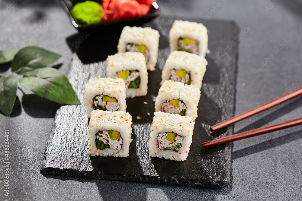 Maki sushi on dark stone table. Sushi roll california in sesame. Maki ...