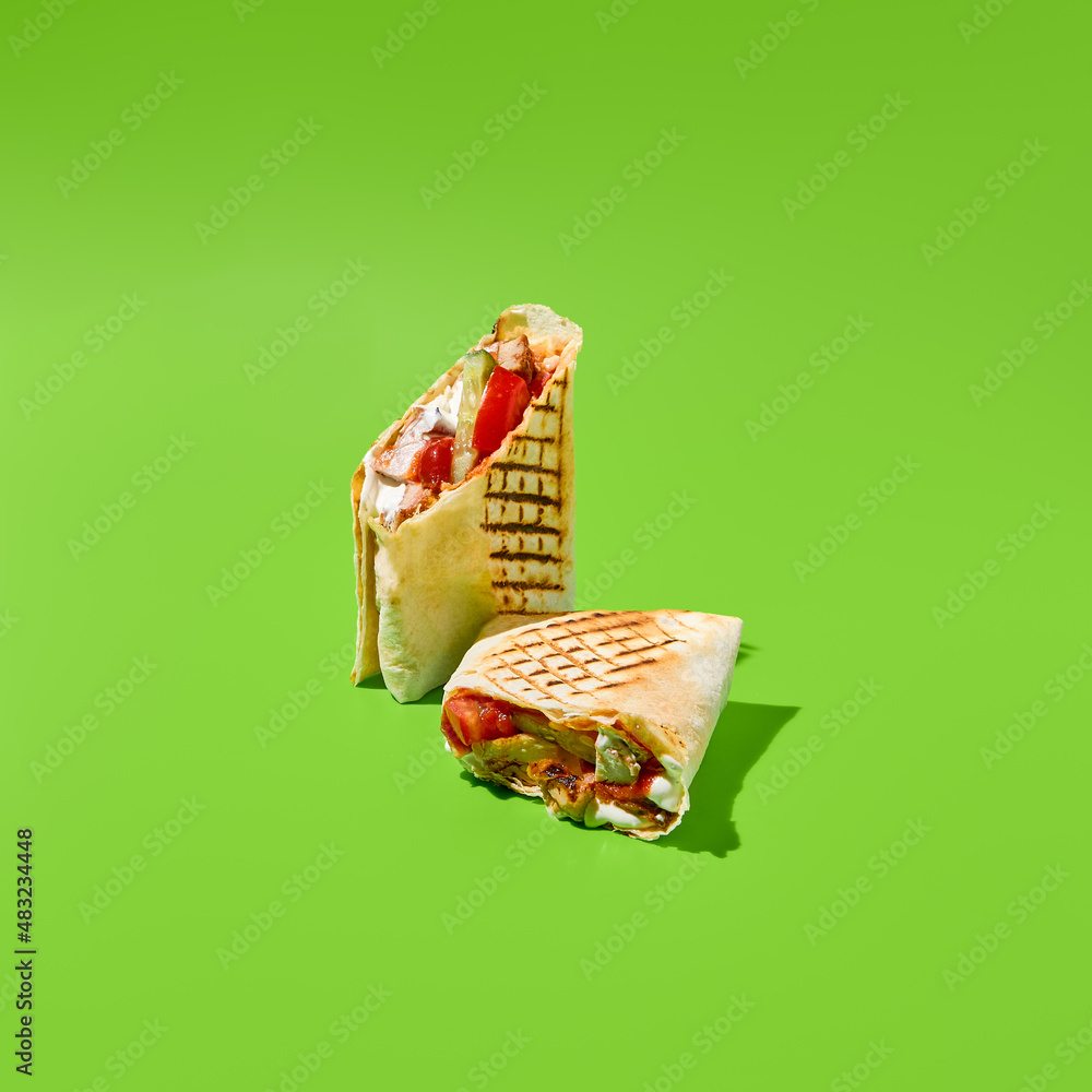 Shawarma with vegetables and meat on green background. Contemporary ...