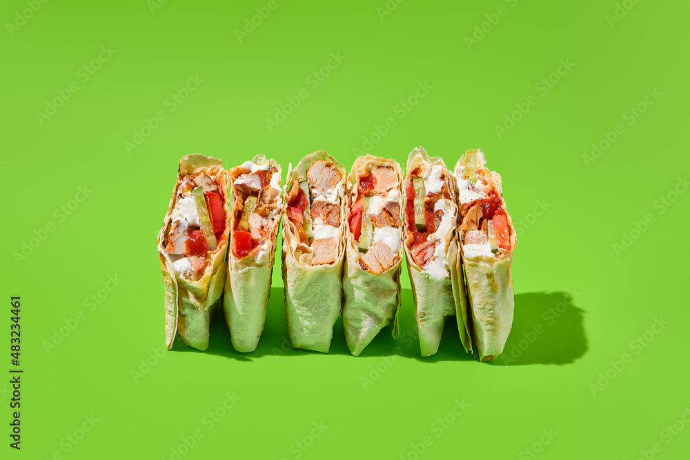 Shawarma with vegetables and meat on green background. Contemporary ...