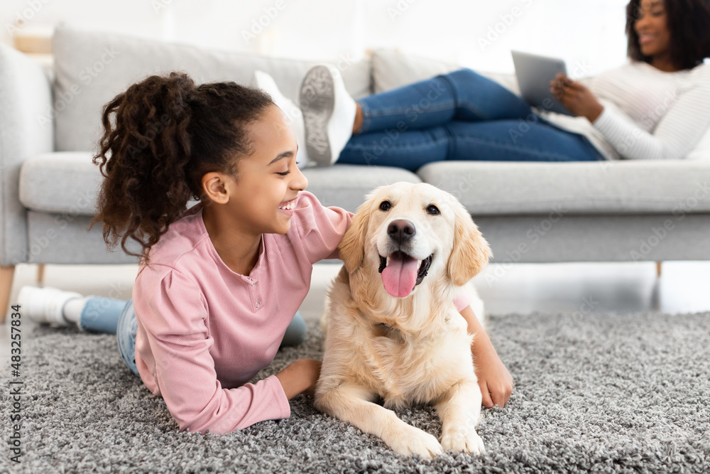 Young black teenage girl having fun with dog at home Stock Photo ...