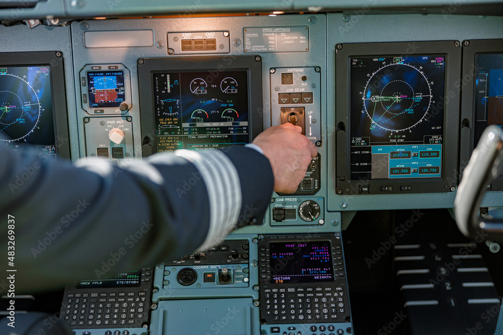 Airline pilot using control panel in aircraft cockpit Stock Photo ...