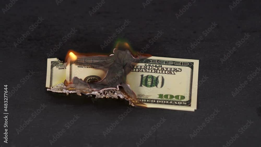 dollar bill burns with flames on black background. fire from gas set ...