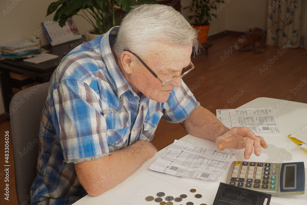 Senior man sitting at the table and calculating finances. Old man ...