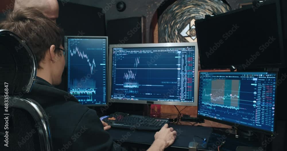 Two male traders on stock exchange, discussing charts of falling and ...