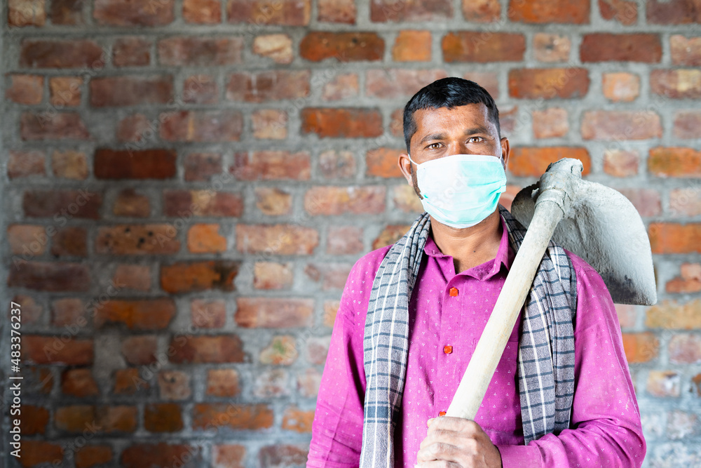 confident construction worker with medical face mask looking camera at ...