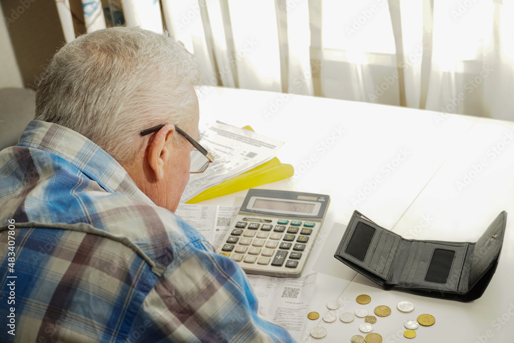 Senior man sitting at the table and calculating finances. Old man ...