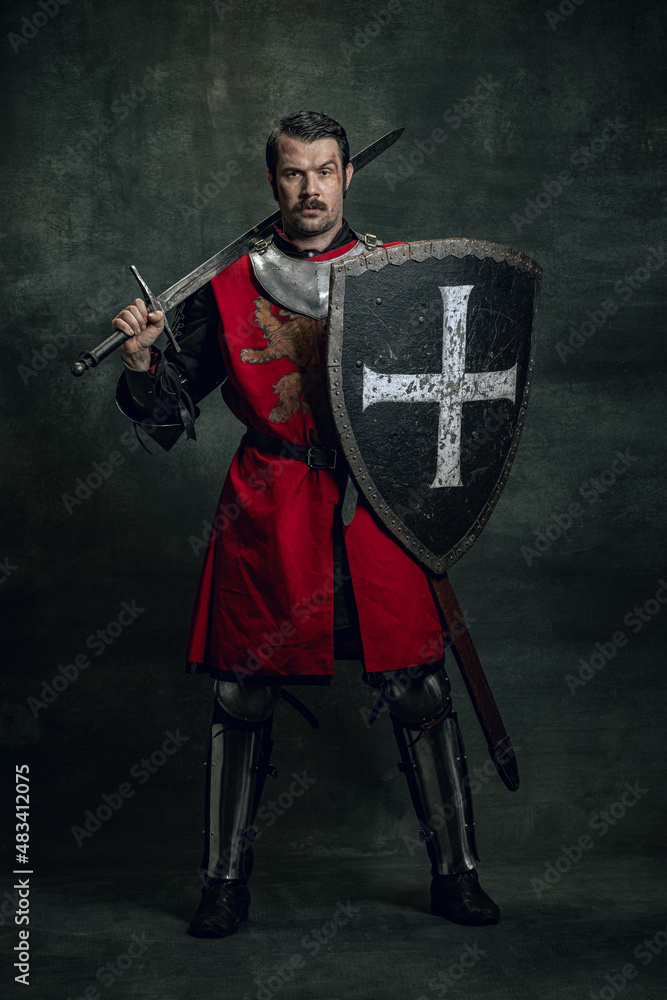 Portrait of medieval warrior or knight with dirty wounded face holding ...