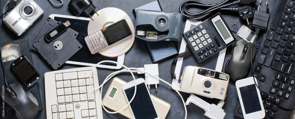 Old electronic devices on a dark background. The concept of recycling ...