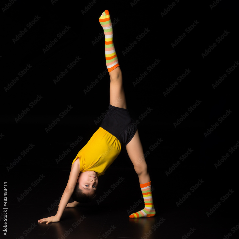 Foto de Boy gymnast doing splits leaning on his hands do Stock | Adobe ...