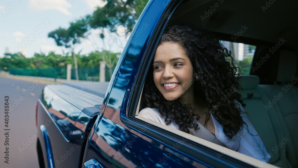 Latin woman in car window. Car trip. Curly hair in wind. Girl looks out ...