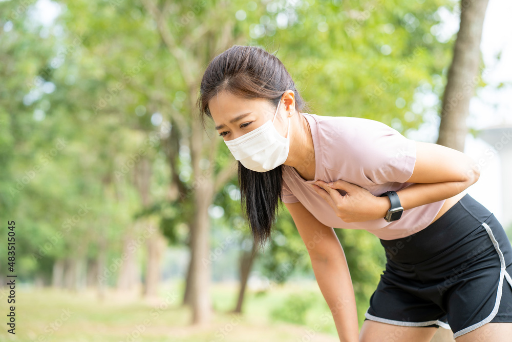 Asian woman runner wearing mask has chest pain and dizziness ...