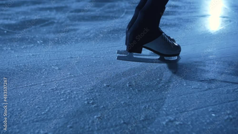 Detail shot of women's legs in figure skating skates sliding on cold ...