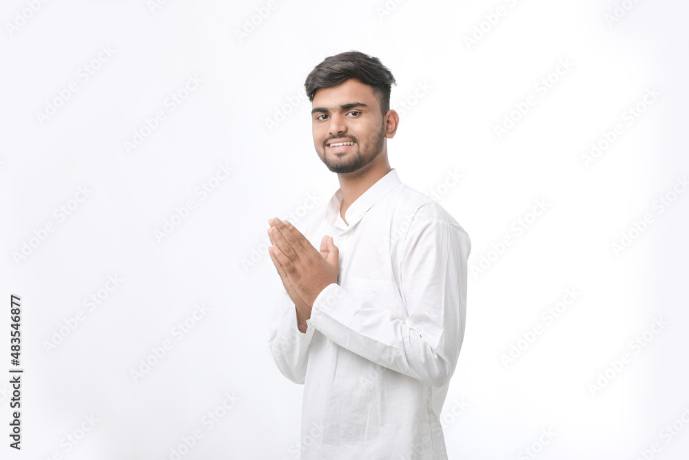 Young indian man in traditional wear and giving namaste or welcome ...