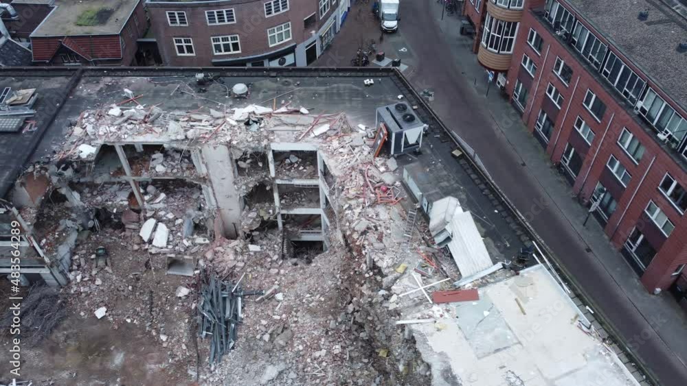 Demolition of a police station using building hydraulic shears, aerial ...