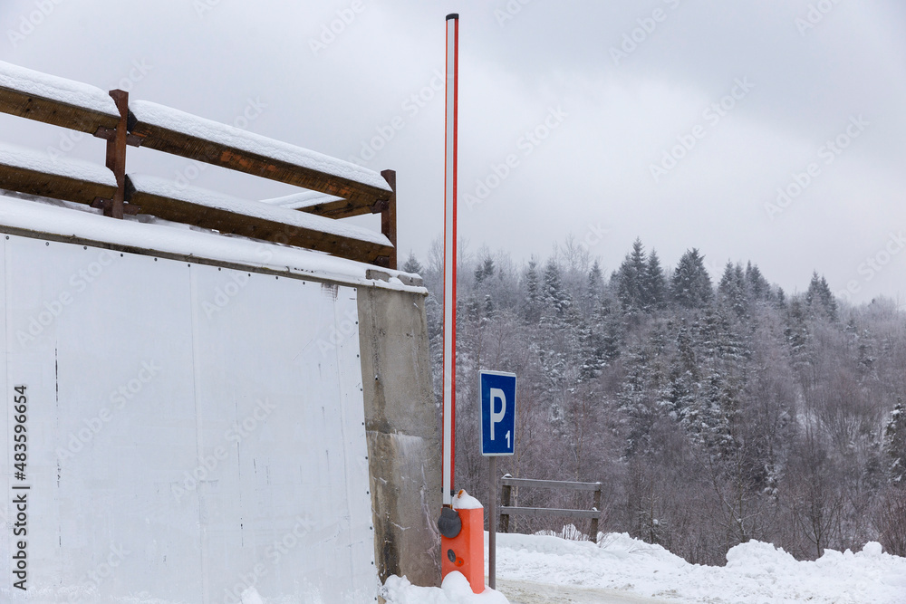 Automatic barrier and entrance to the parking lot in the snowy winter ...