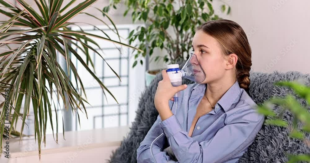 Teenage girl makes inhalation with a nebulizer equipment. Sick child ...