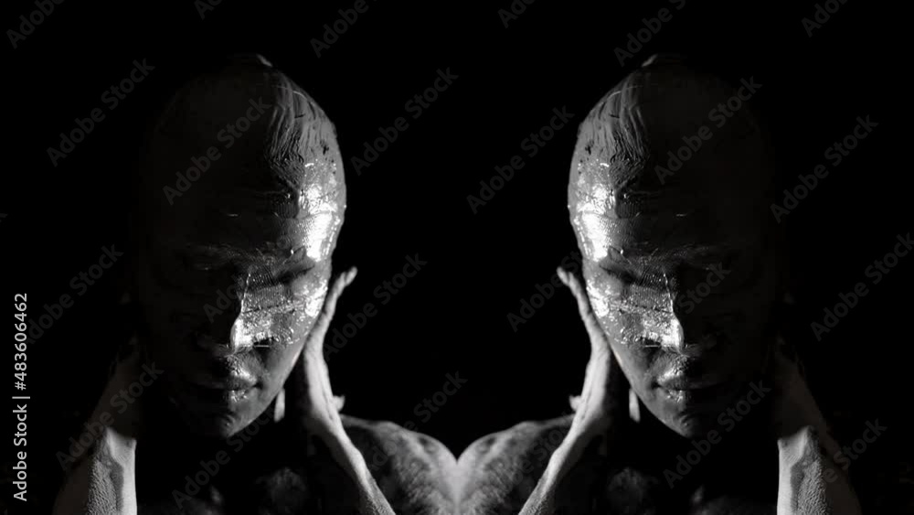 two faces of one woman with blindfold and clay of skin in darkness ...
