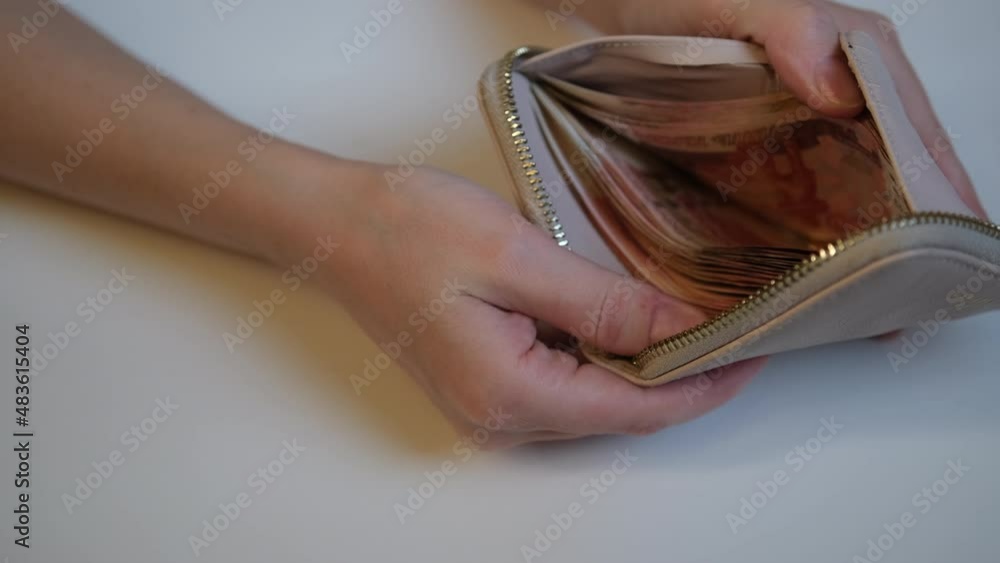 Women's hands open a wallet on a white background and demonstrate that ...