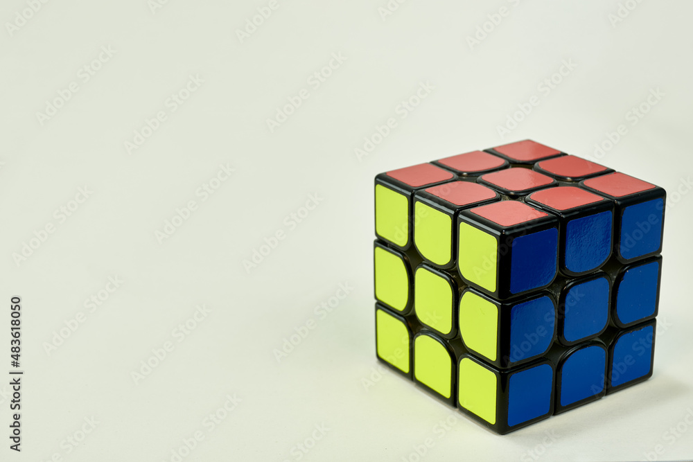 solved rubik's cube in blue, yellow and orange on white background ...
