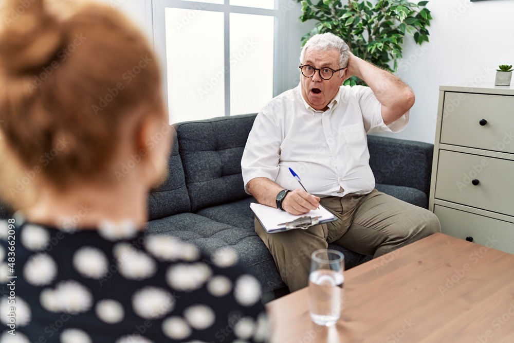 Senior psychologist man at consultation office crazy and scared with ...