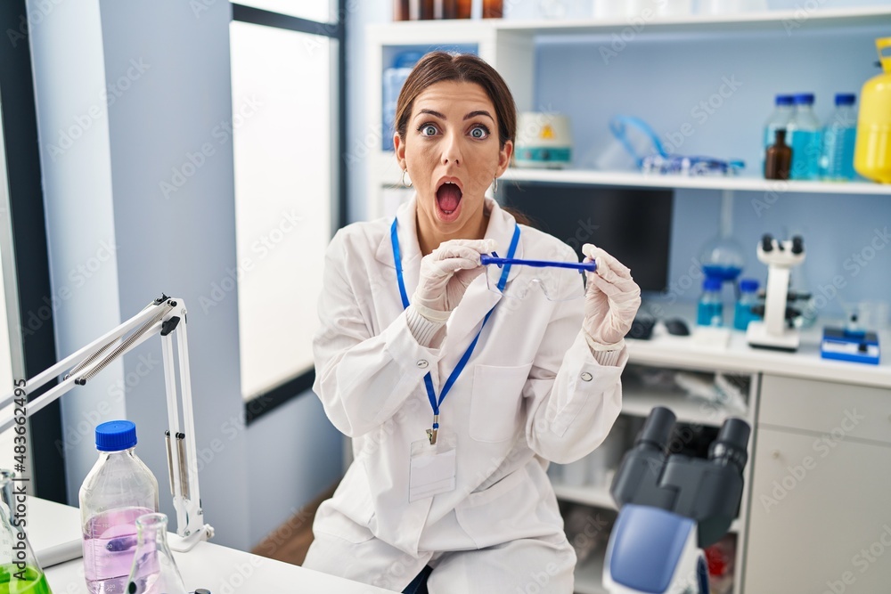 Young brunette woman working at scientist laboratory wearing safety ...