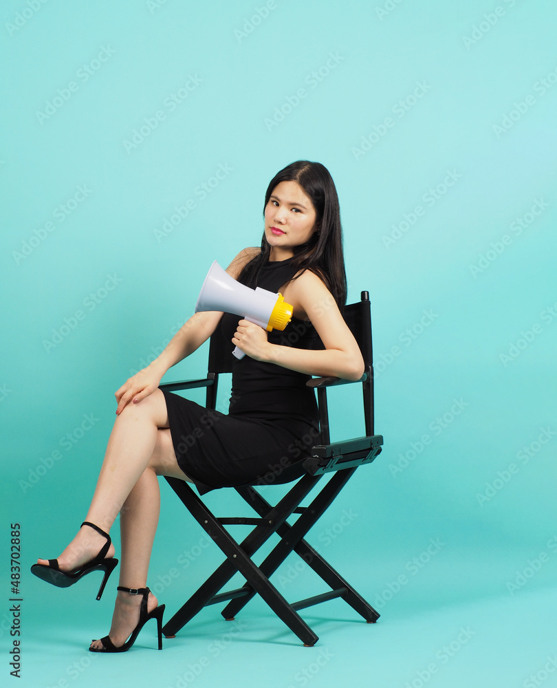 Black director chair.Asian woman is holding megaphone and sitting on ...