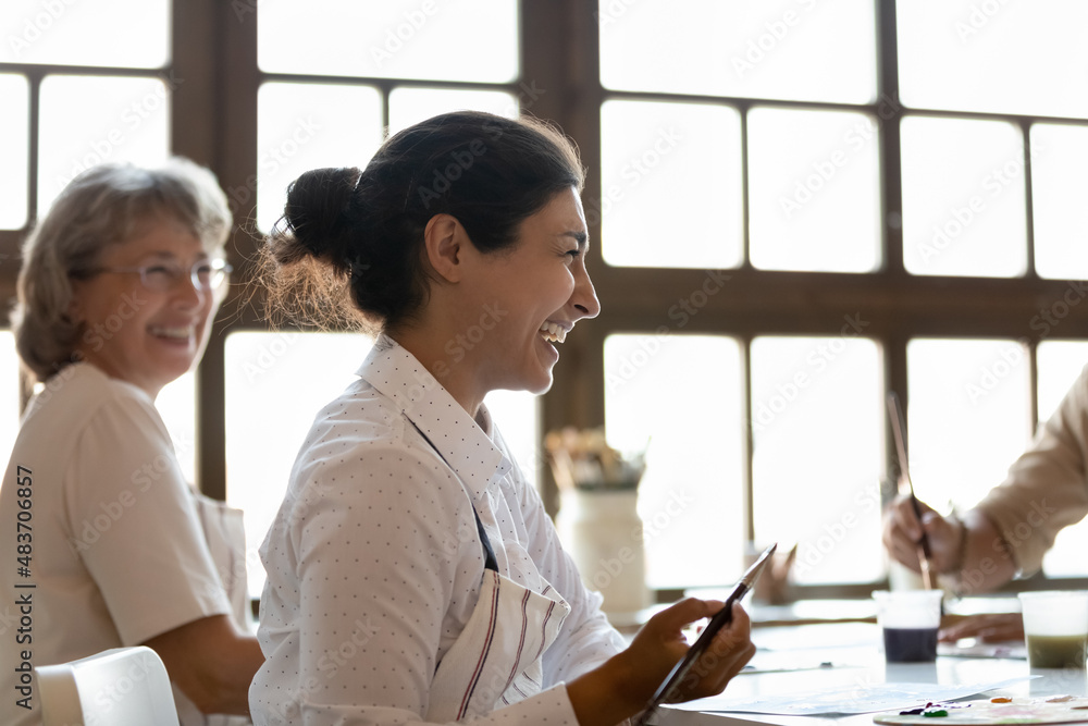 Happy joyful Indian student girl in apron and glasses studying drawing ...