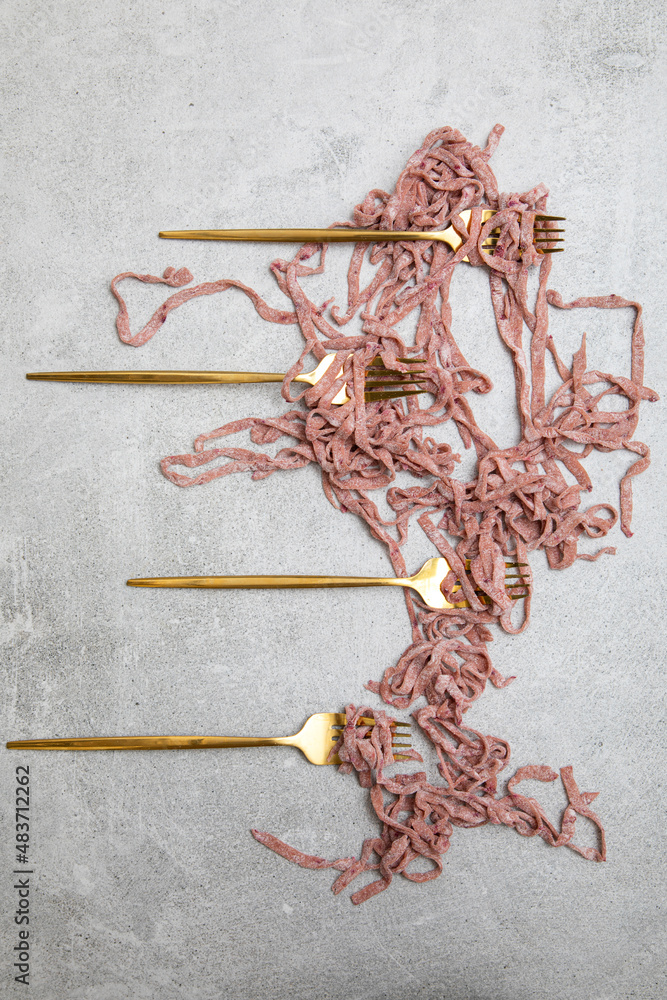 beetroot pasta, with golden forks on a slate background Stock Photo ...