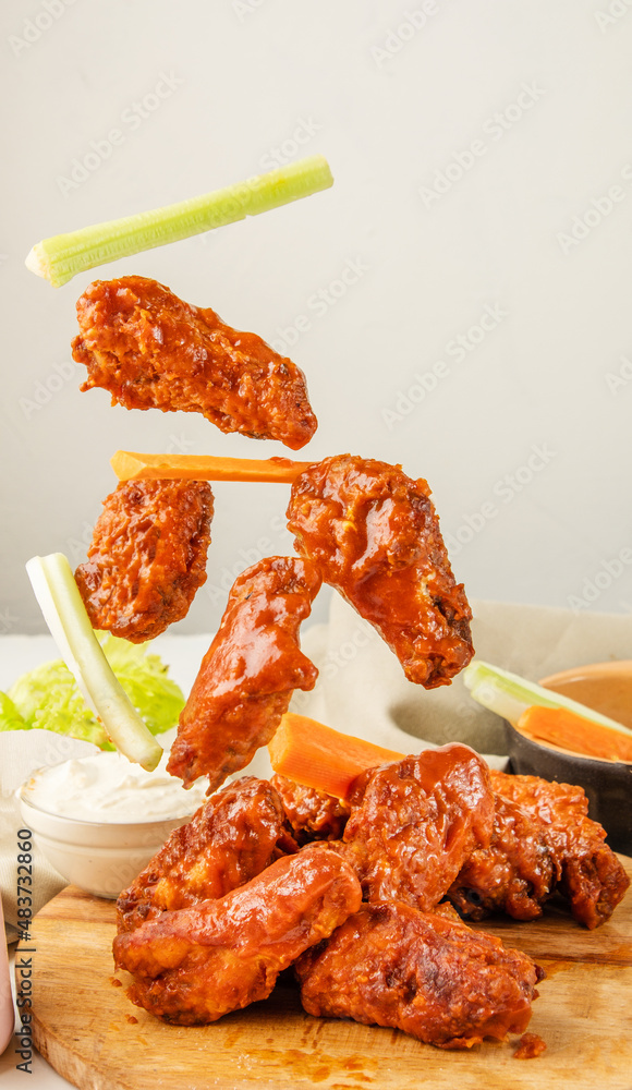 Falling chicken wings buffalo sauce with carrot and celery sticks ...