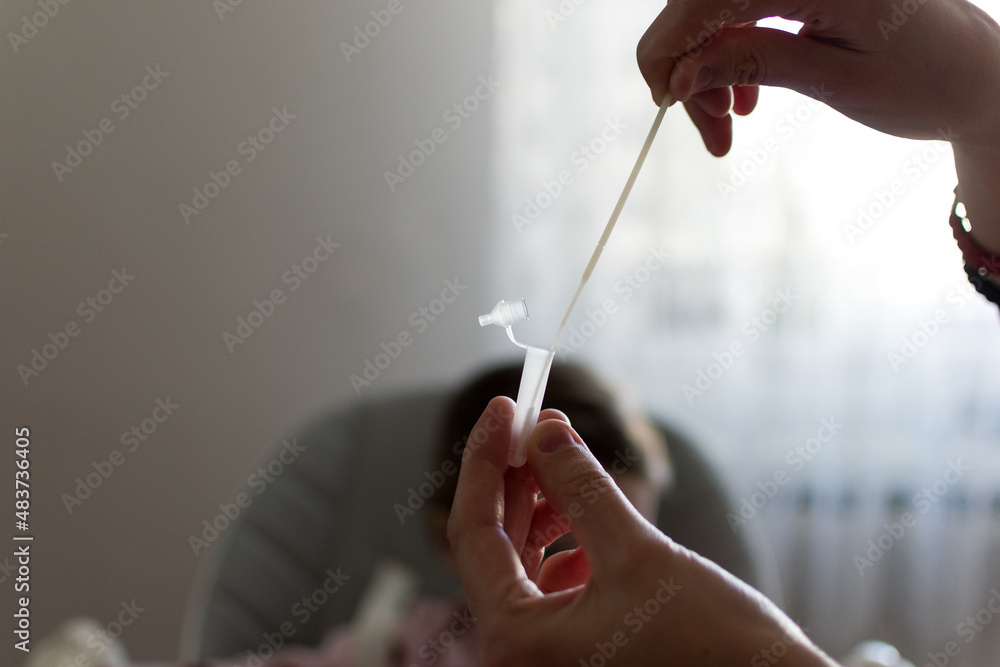 Mother performing a mouth swab test on a little child. Child going ...
