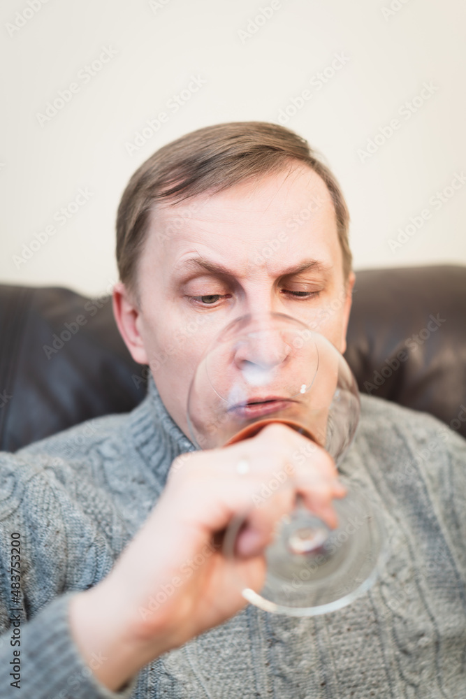 Relaxed serene rich lonely middle aged single man drinking red wine ...