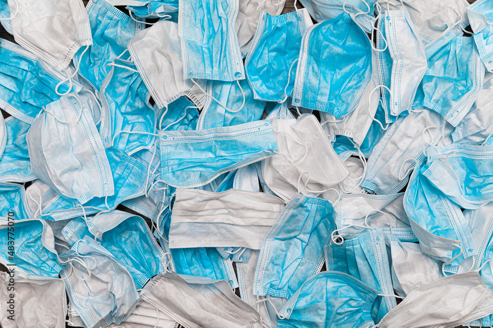 Used medical masks. Pile of used personal protective equipment PPE ...