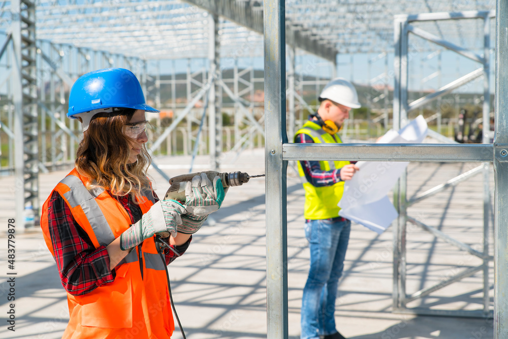 The professional young women worker works on installation of a metal ...