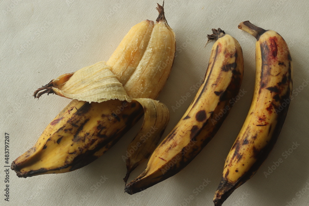 Twin Ripe plantain yellow in colour, ready to eat with skin half peeled ...