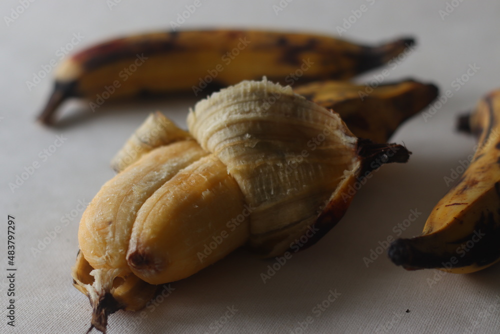 Twin Ripe plantain yellow in colour, ready to eat with skin half peeled ...