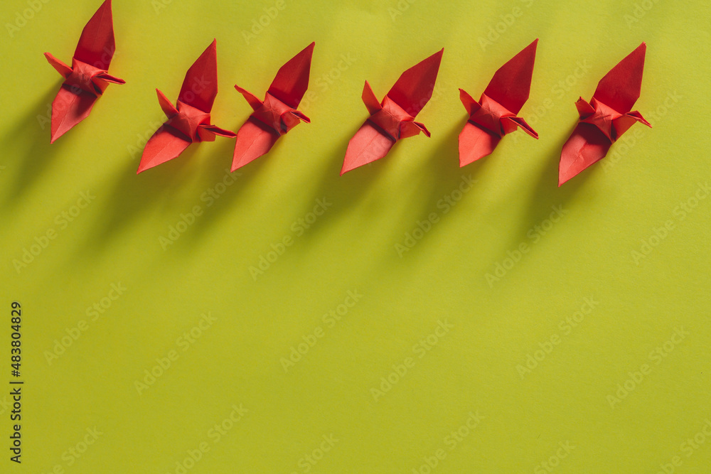 Seven red Origami Birds are flying leading by a pink bird, isolated on ...