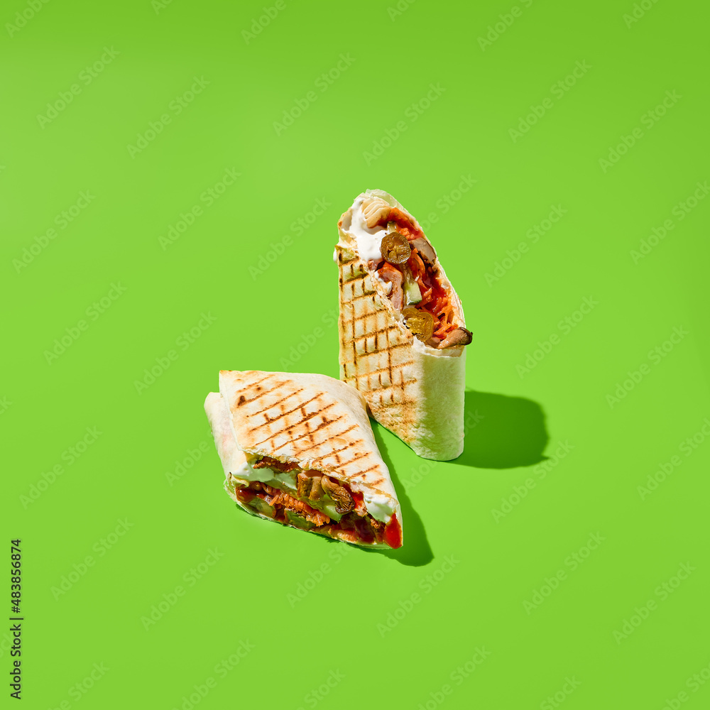 Shawarma with vegetables and meat on green background. Contemporary ...