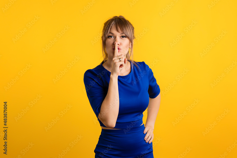 Girl Make Silence Gesture And Looking At Camera on Yellow Background ...