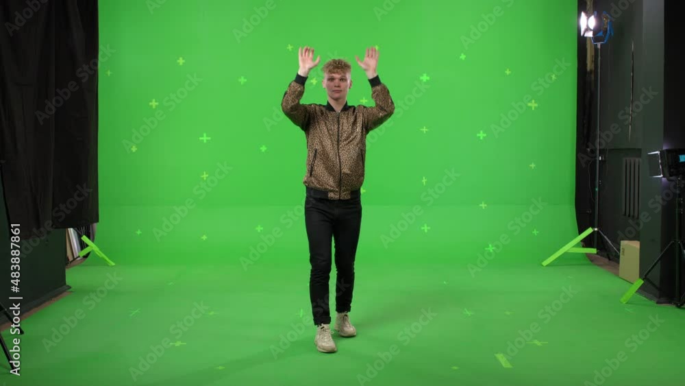 A young man dancing on a green screen background. Attractive guy guy ...