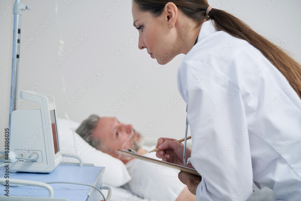 Poster Concentrated female physician checking male vital signs – Wall ...