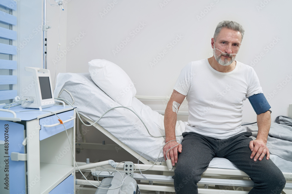 Adult male patient sitting connected to oxygen concentrator Stock Photo ...
