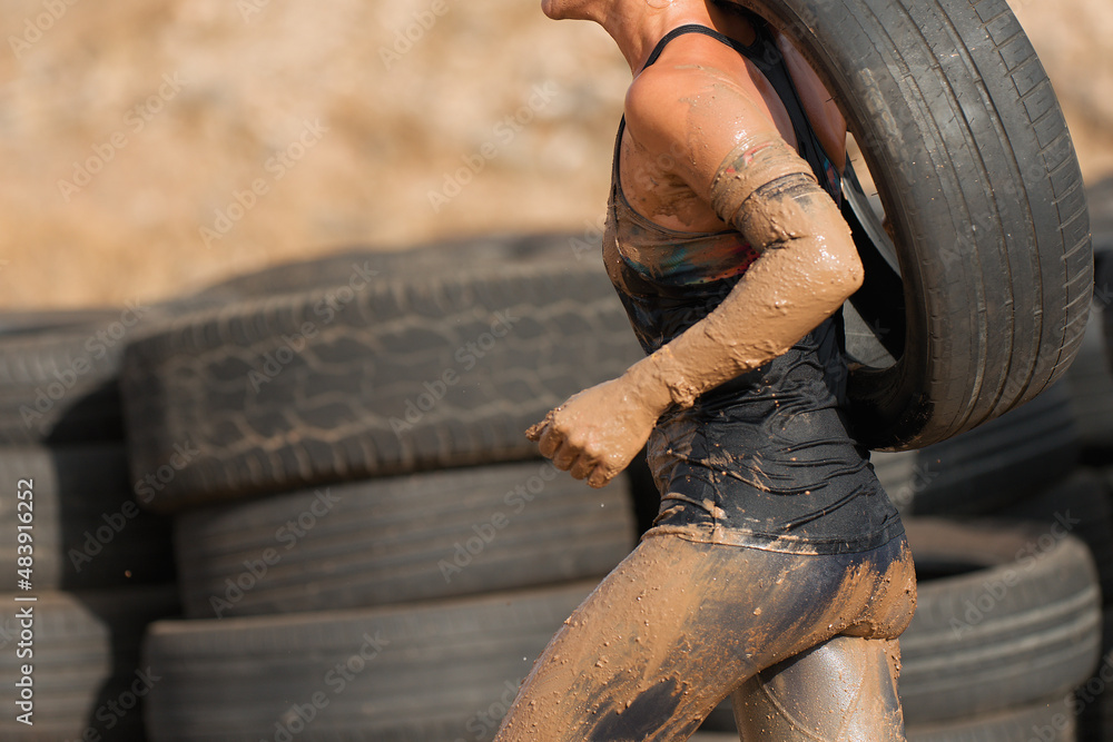 Mud race runner. Runner carrying tire in a test of the race Stock Photo ...
