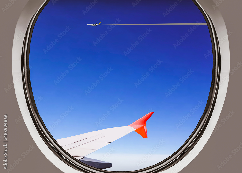 Airplane window view during a daytime flight above clouds creating an ...