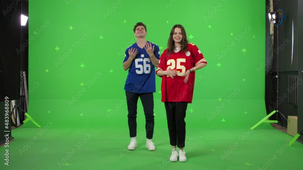 A young couple dancing making content on a green screen background. A ...