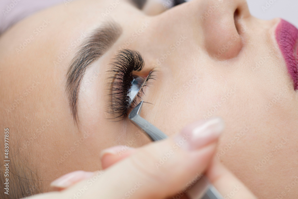 Extension of the lower eyelashes. a young woman undergoes a close-up ...