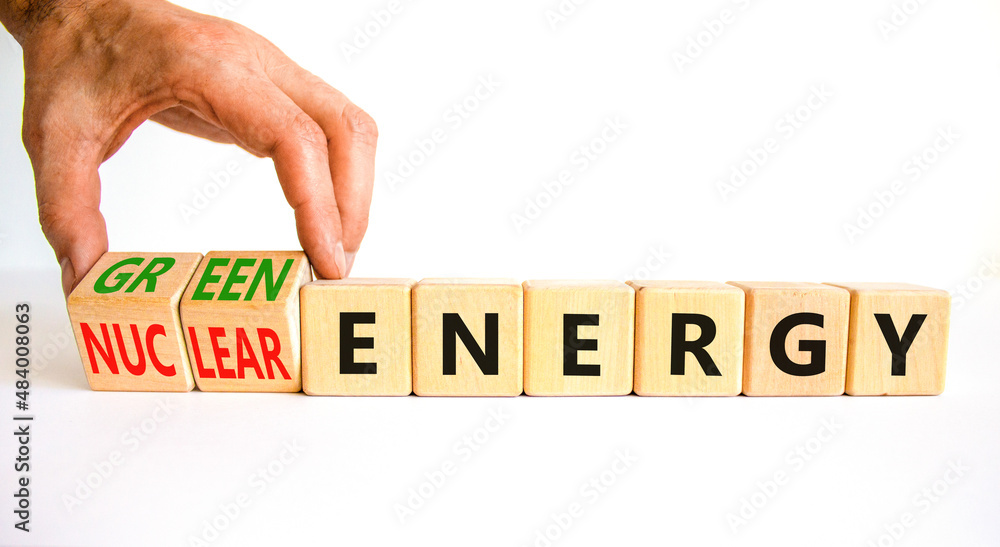 Nuclear or green energy symbol. Businessman turns wooden cubes and ...