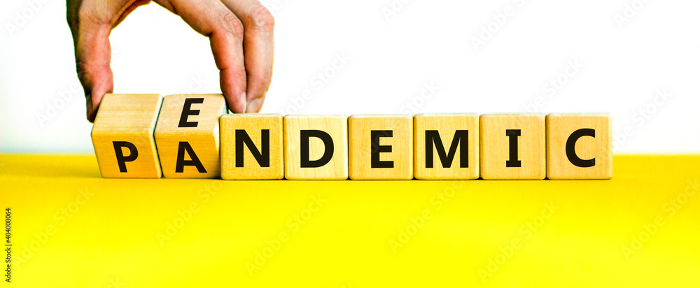 Covid-19 pandemic or endemic symbol. Doctor turns wooden cubes and ...